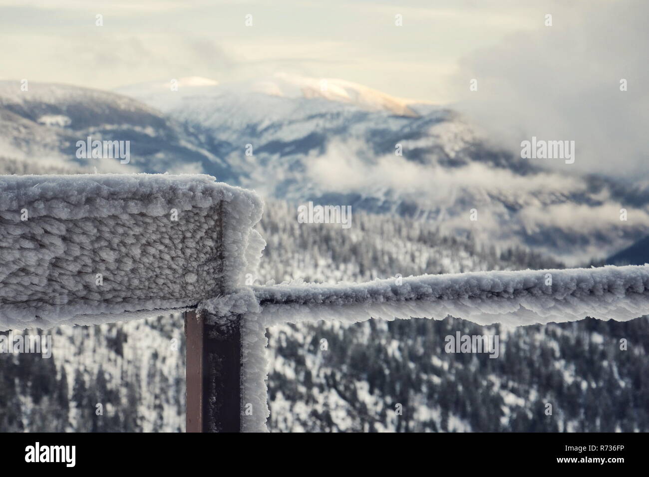 Big hoarfrost on metallic railing with snowy mountains landscape ...