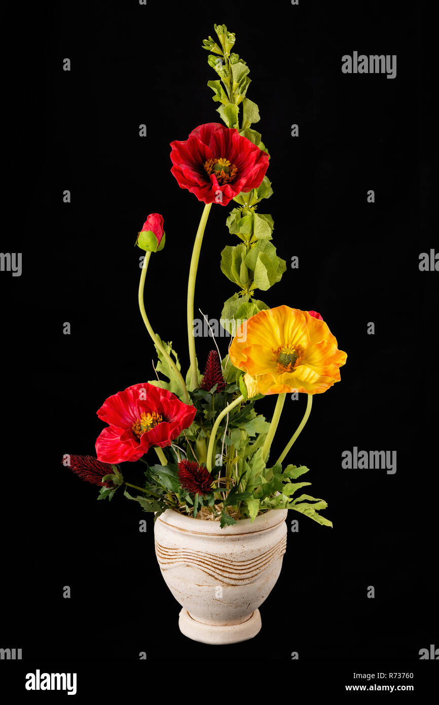 Floral arrangement from artificial poppy flowers in old ceramic flower ...
