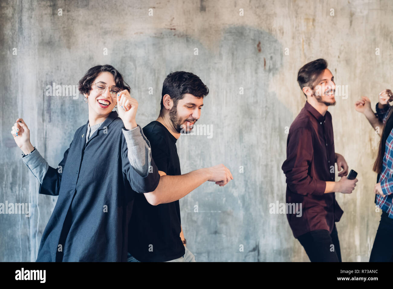 Friends dancing against backdrop of concrete wall Stock Photo - Alamy