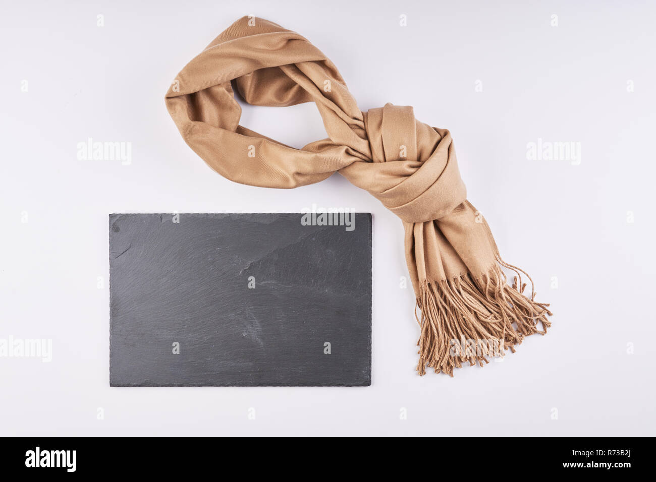 Scarf is tied in beautiful knot and granite slab on white background ...