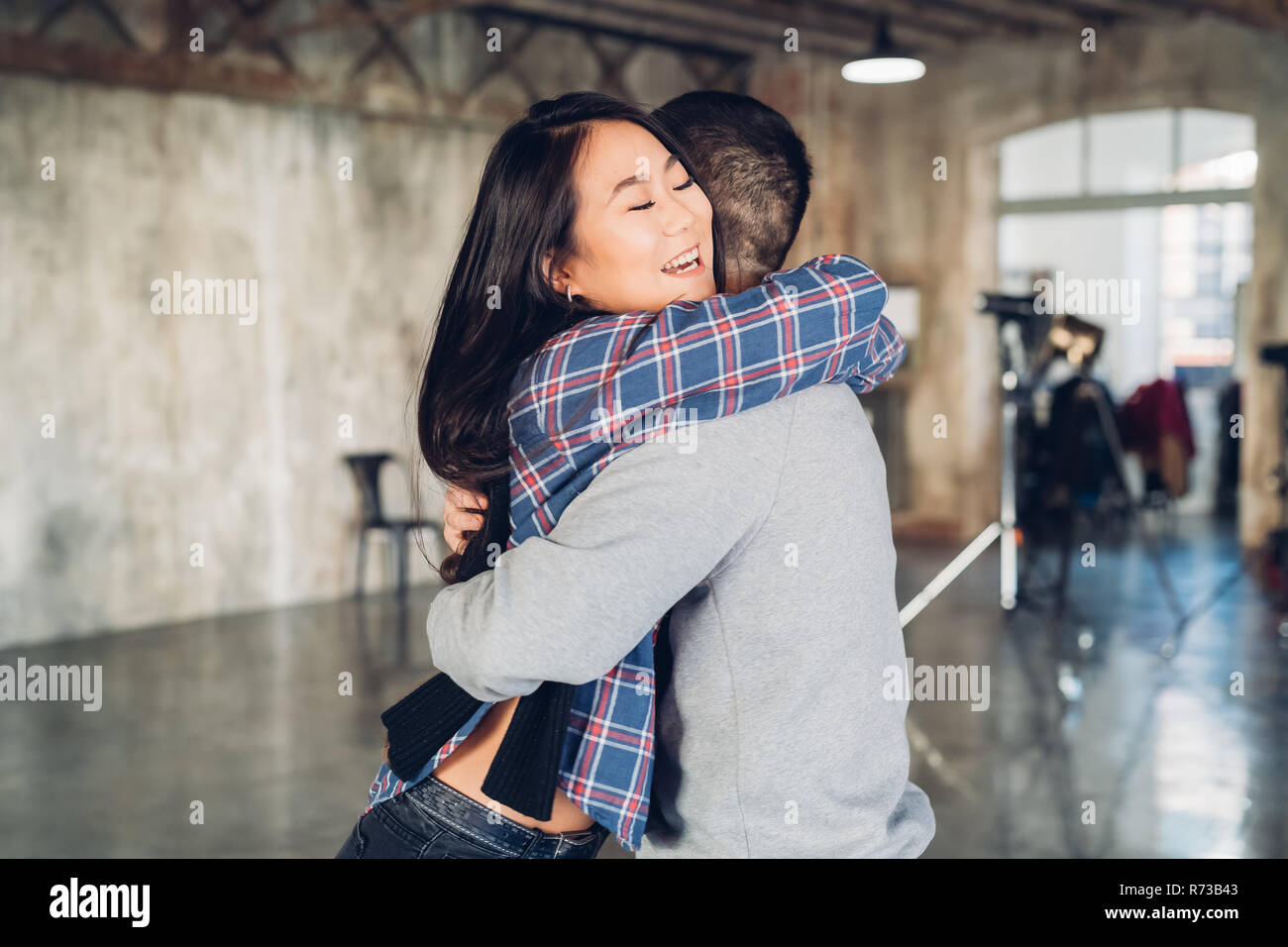 Couple hugging in open plan studio Stock Photo - Alamy