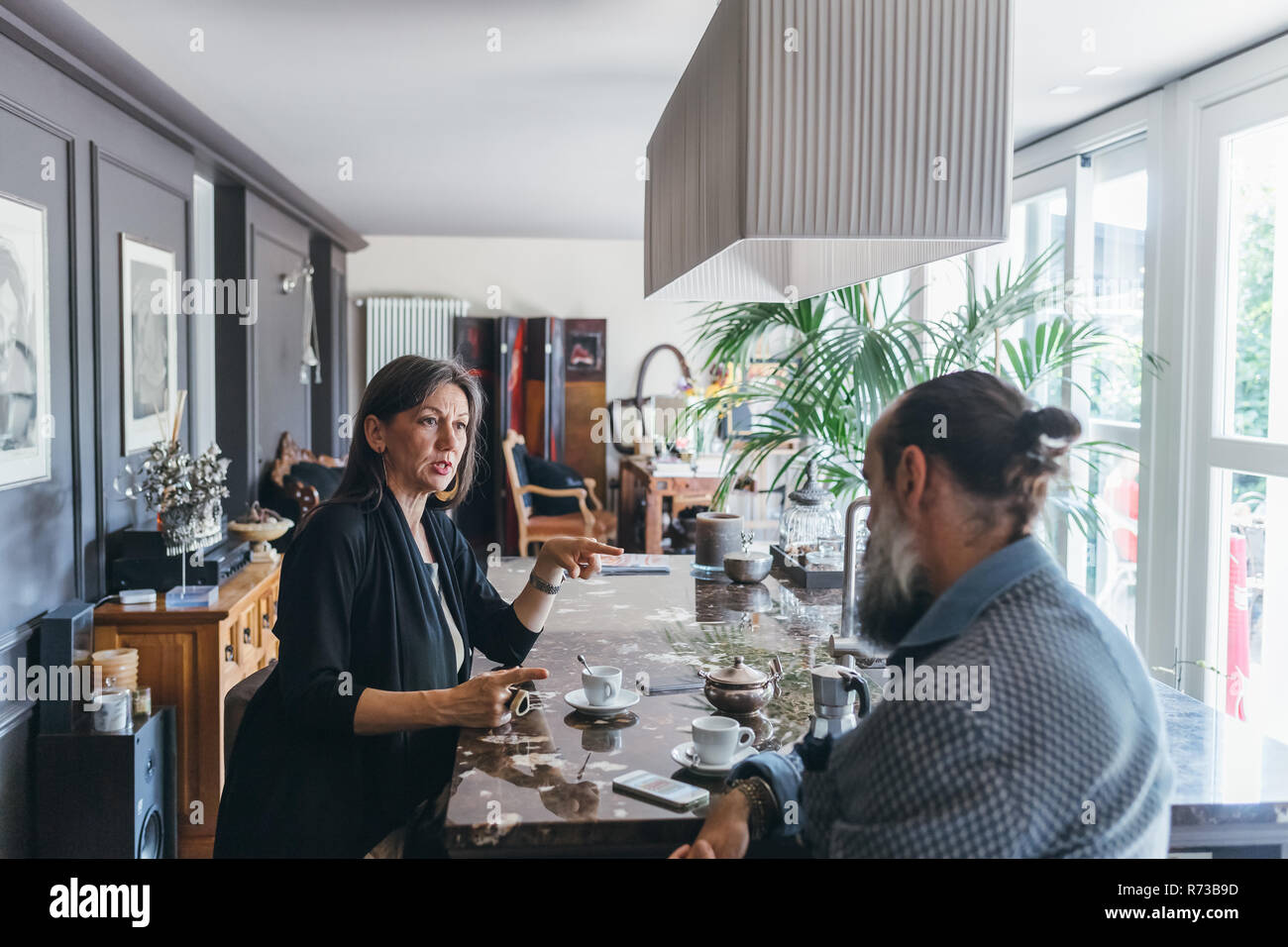 Couple in discussion over coffee in kitchen Stock Photo - Alamy