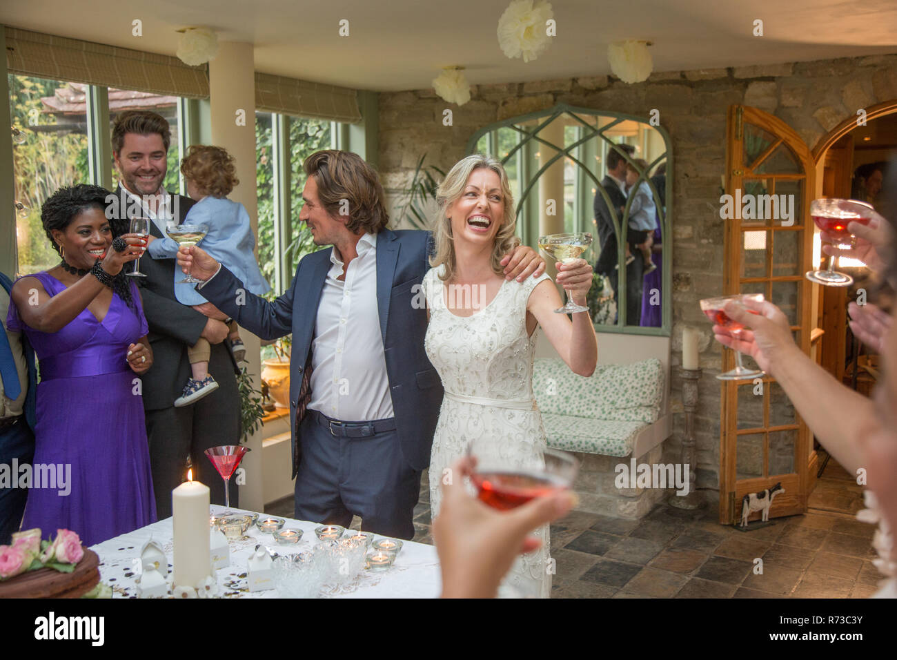 Wedding guests toasting to newlyweds at reception Stock Photo - Alamy