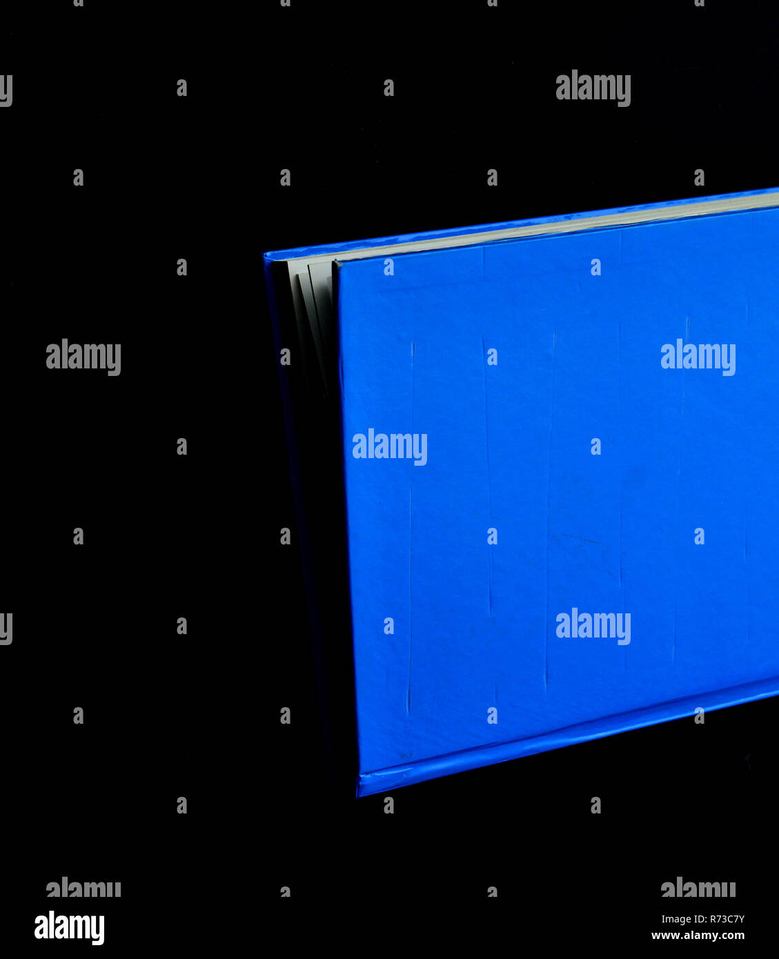 blue book on a black background, isolated, image of a Stock Photo - Alamy