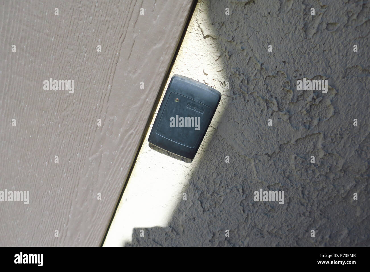 A card tap acess port on a stucco wall lit up by sunlight Stock Photo ...