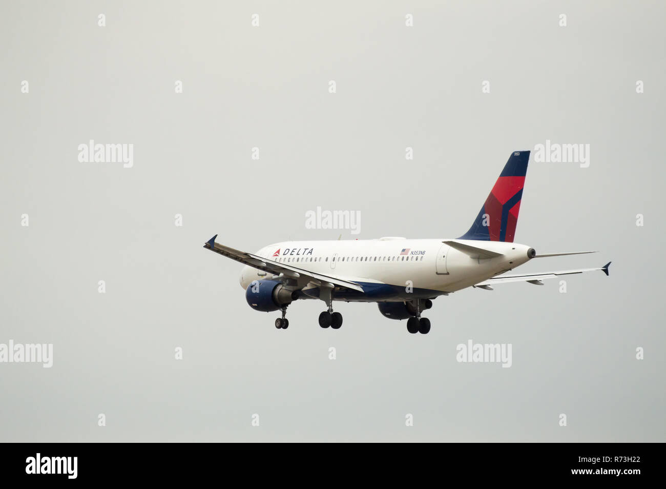 A delta passenger jet coming down to land in a gray sky Stock Photo - Alamy