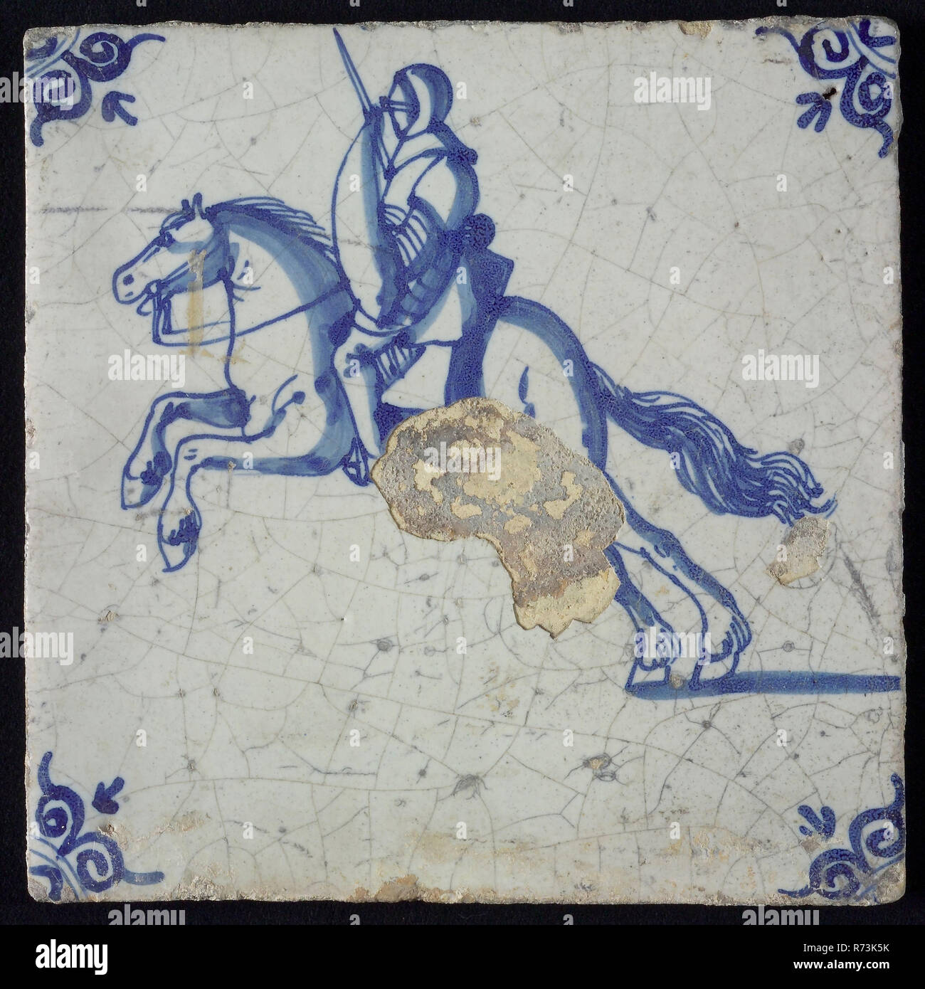 White tile with blue horseman with armor, shield and sword; corner ...