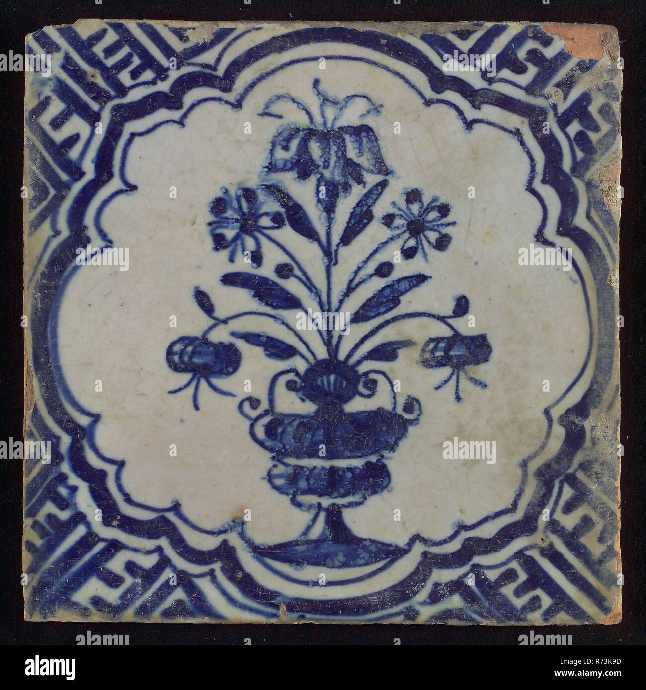 White tile with blue pot with flowers in braid-shaped frame, corner ...