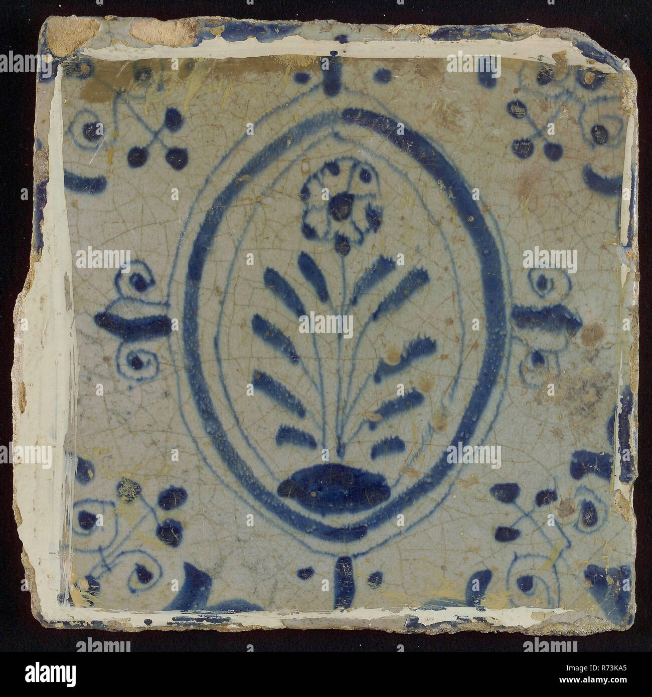 White tile with in blue flower in oval frame; corner motif triptych ...