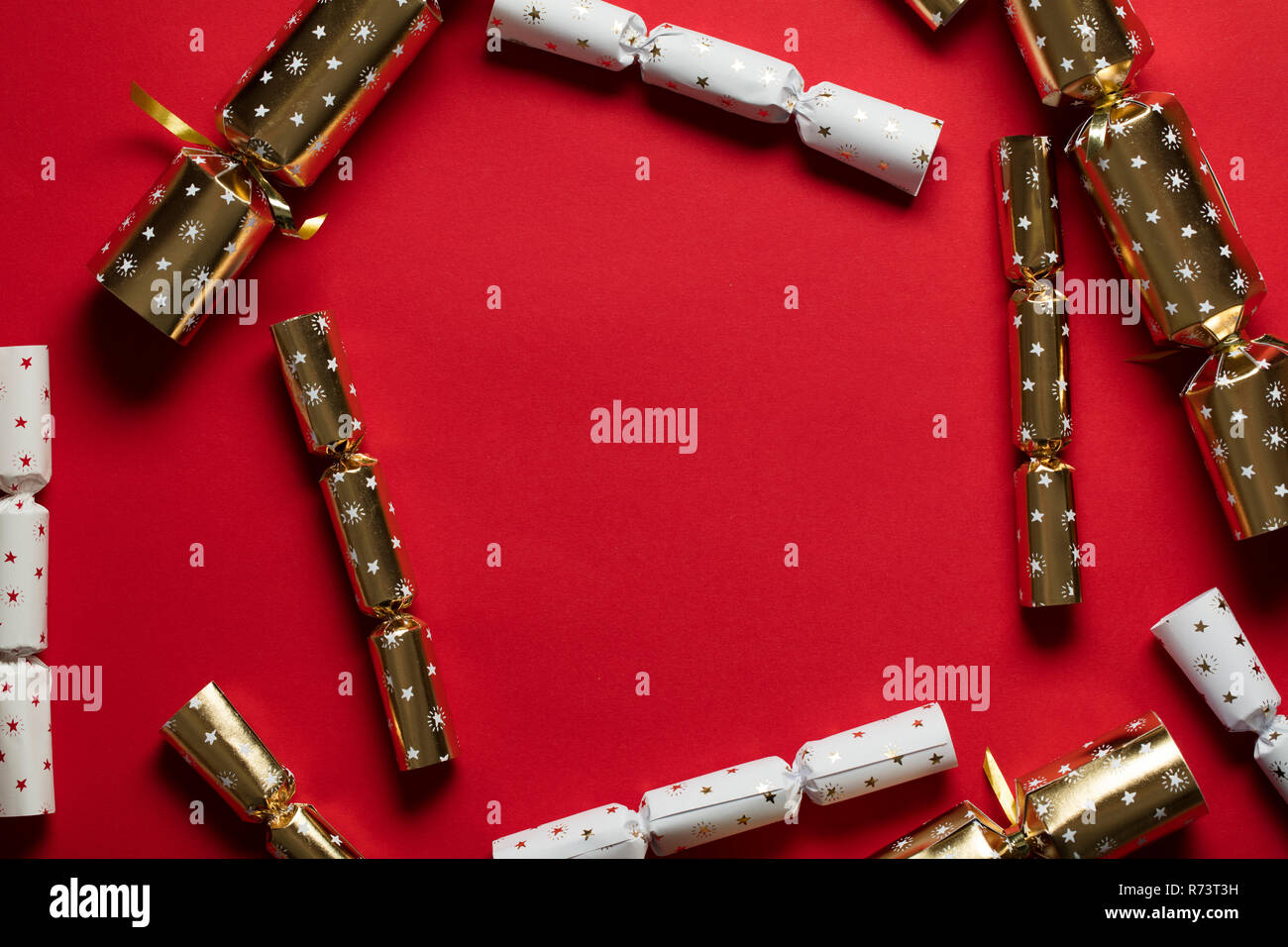 Festive Christmas crackers on a bright red background Stock Photo - Alamy