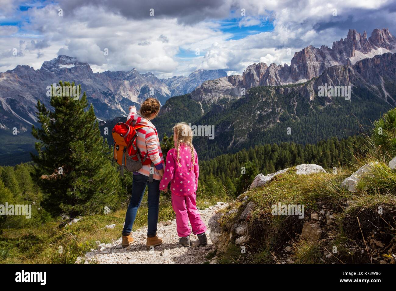 two sisters girls hikers at the mountains Dolomites, Italy. Cinque ...