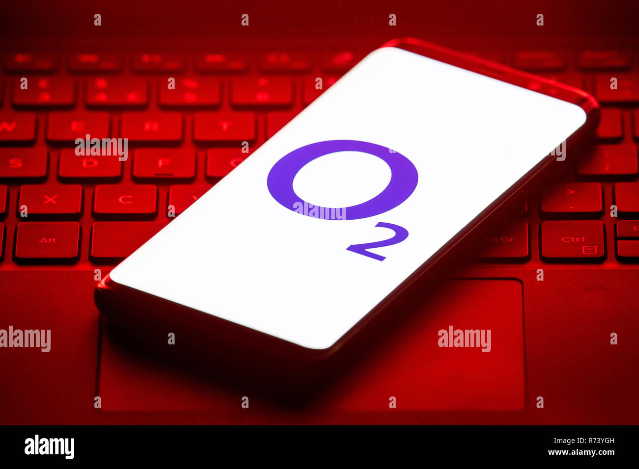 The logo of mobile phone network O2 is displayed on the screen of a ...