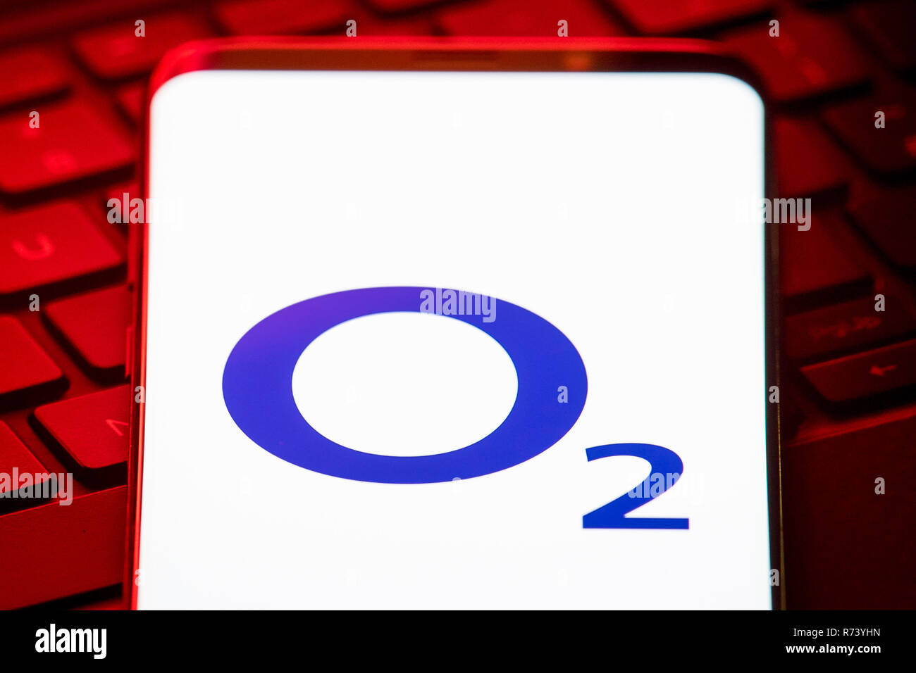 The logo of mobile phone network O2 is displayed on the screen of a ...