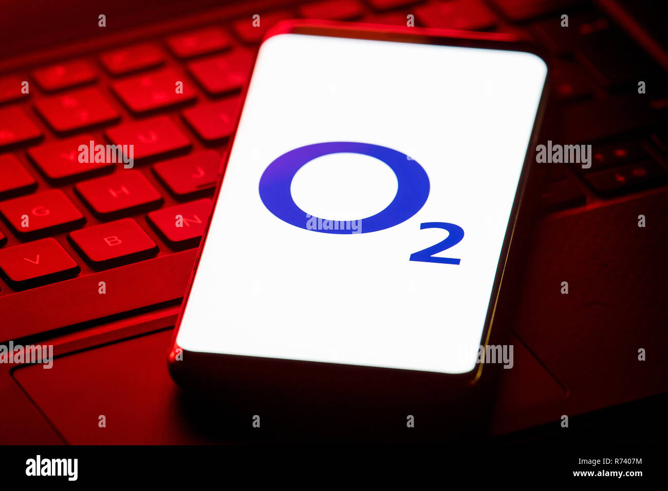 The logo of mobile phone network O2 is displayed on the screen of a ...