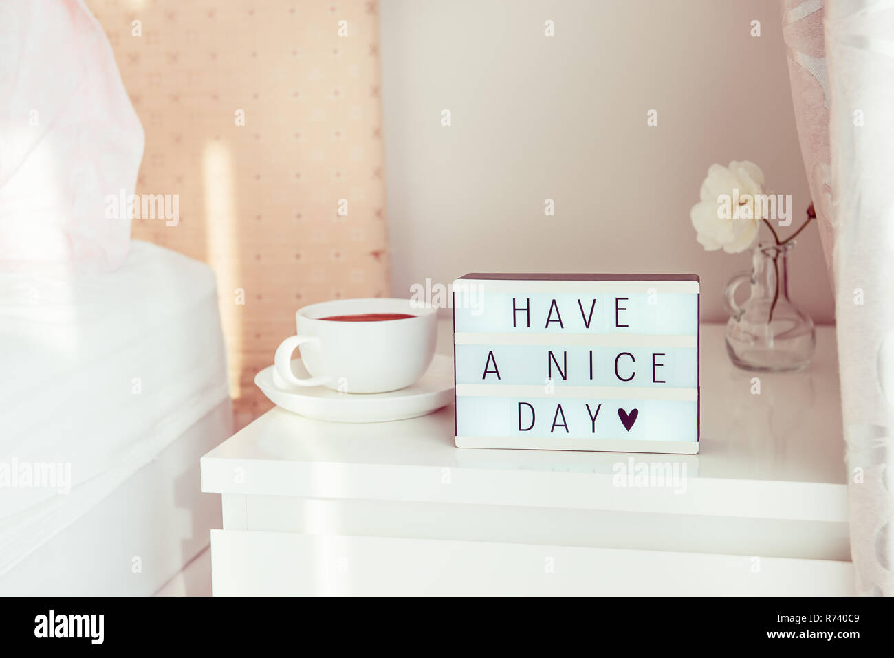 Have a nice day text message on lighted box, cup of coffee and white ...