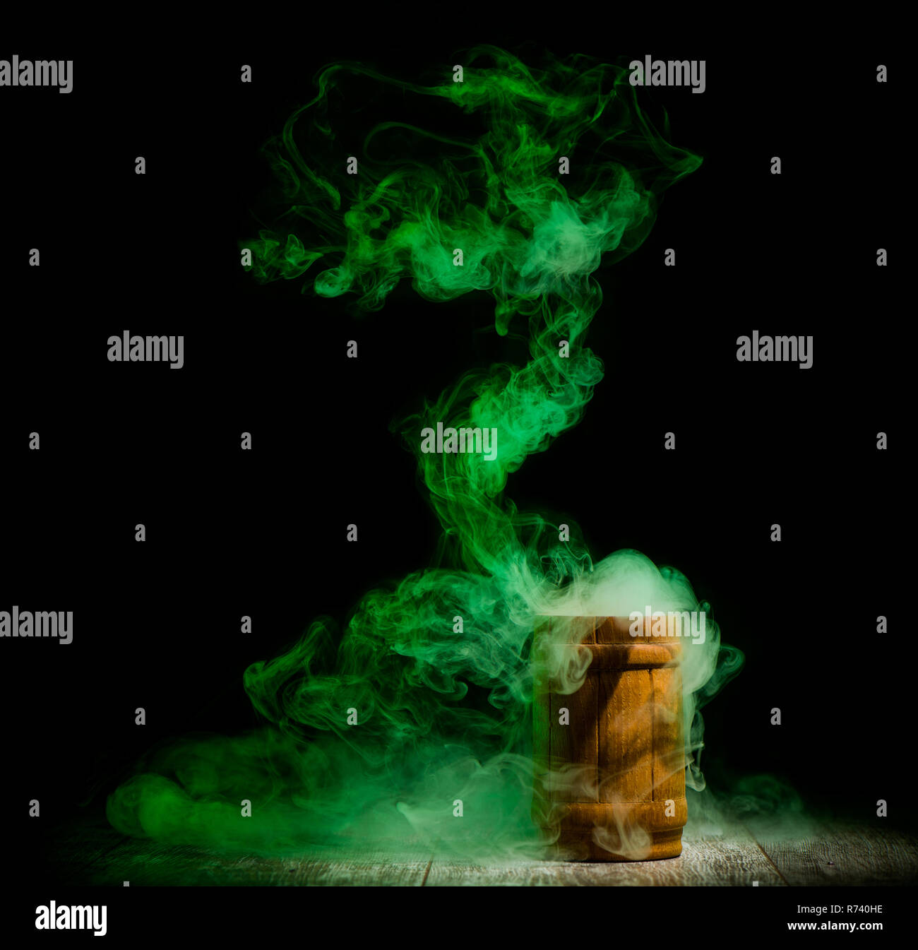 green smoke from wooden jar isolated at dark background Stock Photo - Alamy