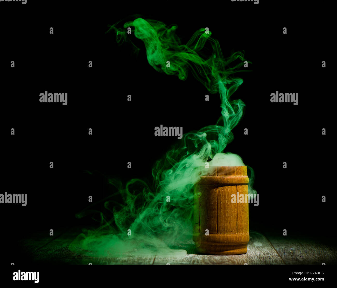green smoke from wooden jar isolated at dark background Stock Photo - Alamy