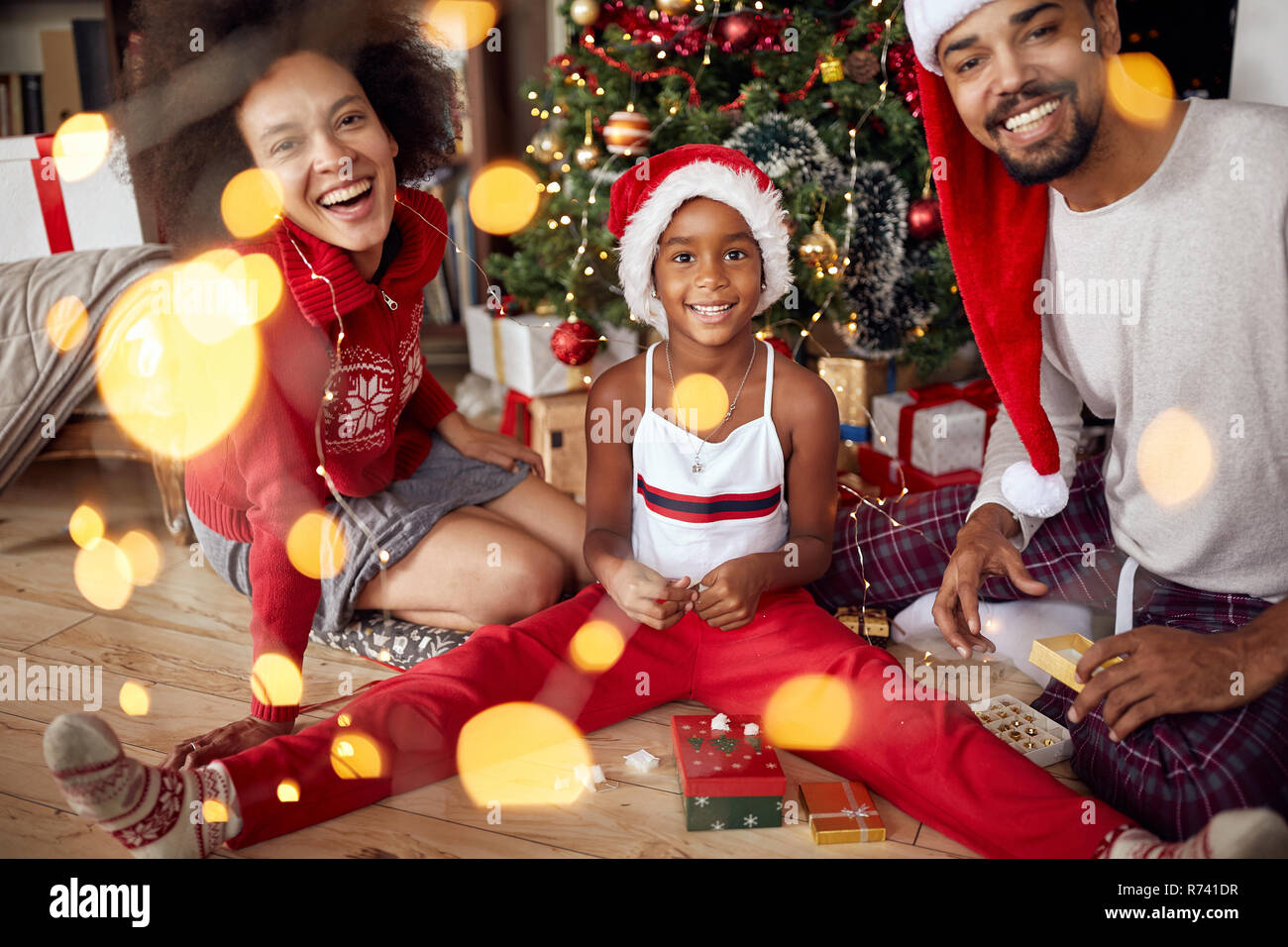 Portrait of smiling family in front of Christmas tree Stock Photo - Alamy