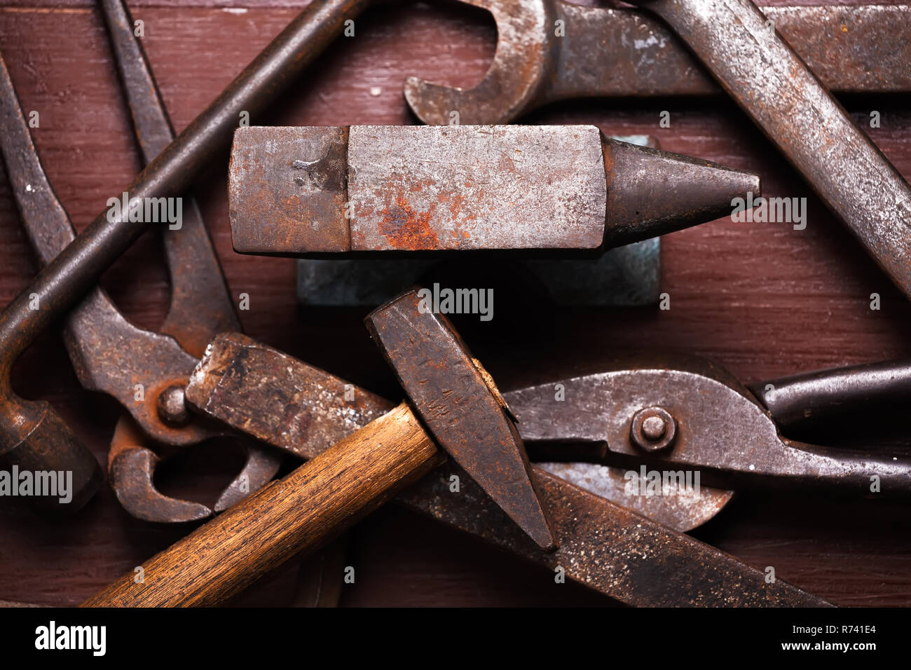 Old rusty rugged anvil and other blacksmith tools on brown natural ...