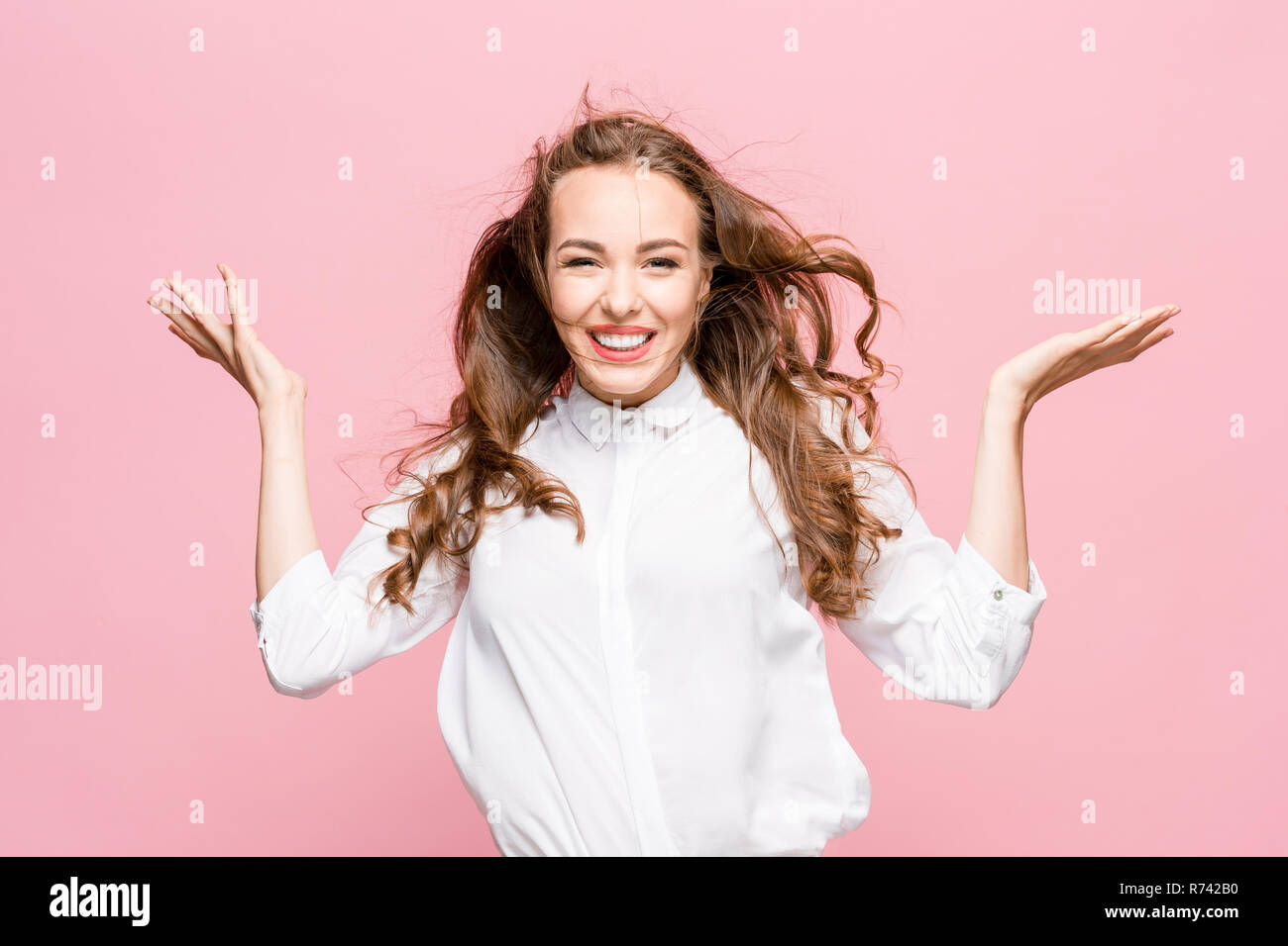 The young woman's portrait with happy emotions on pink background Stock ...