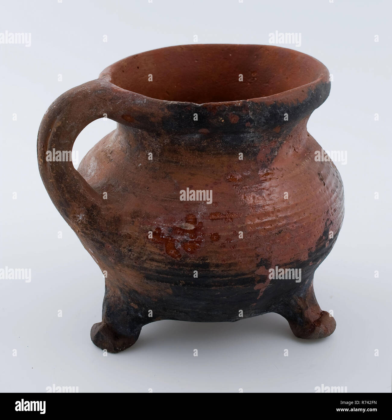 Pottery cooker on three legs, sausage ear and sparing lead glaze, grape ...