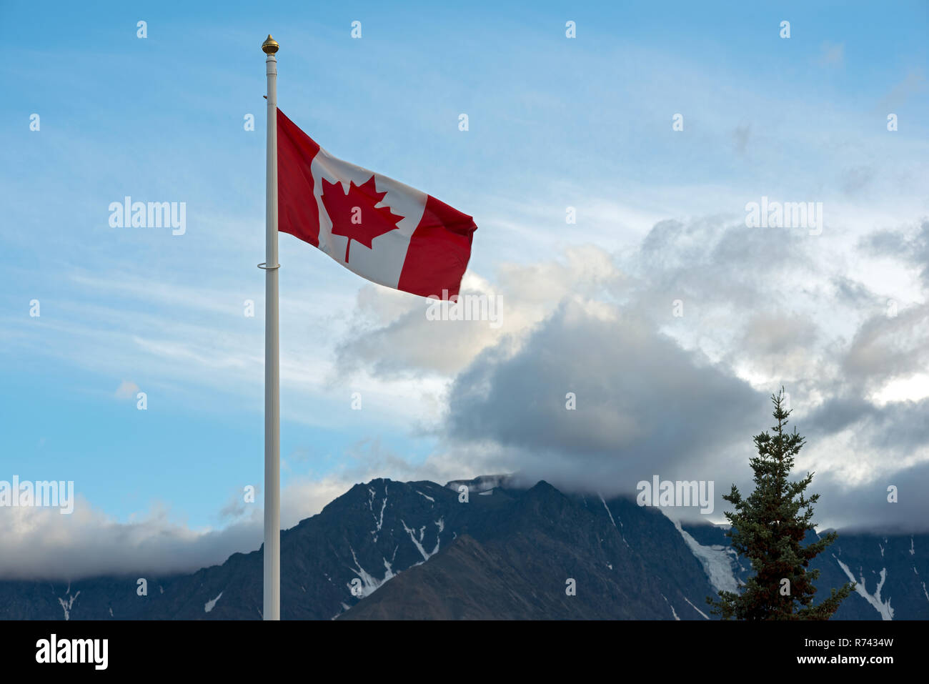The Canadian Flag flying over mountain peaks Stock Photo - Alamy