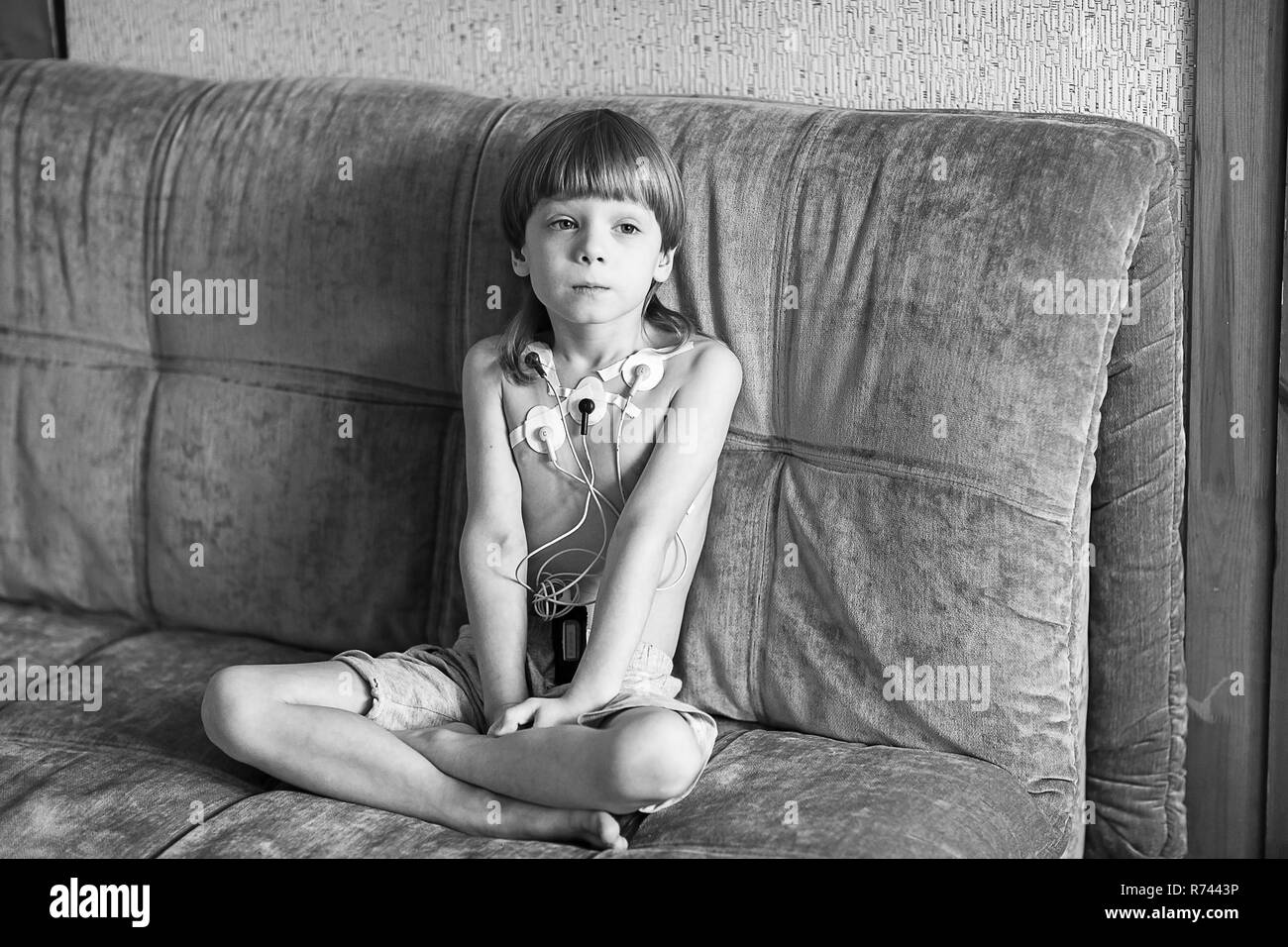 Child sitting on the sofa. Heart cardiogram or monitoring of cardiac ...