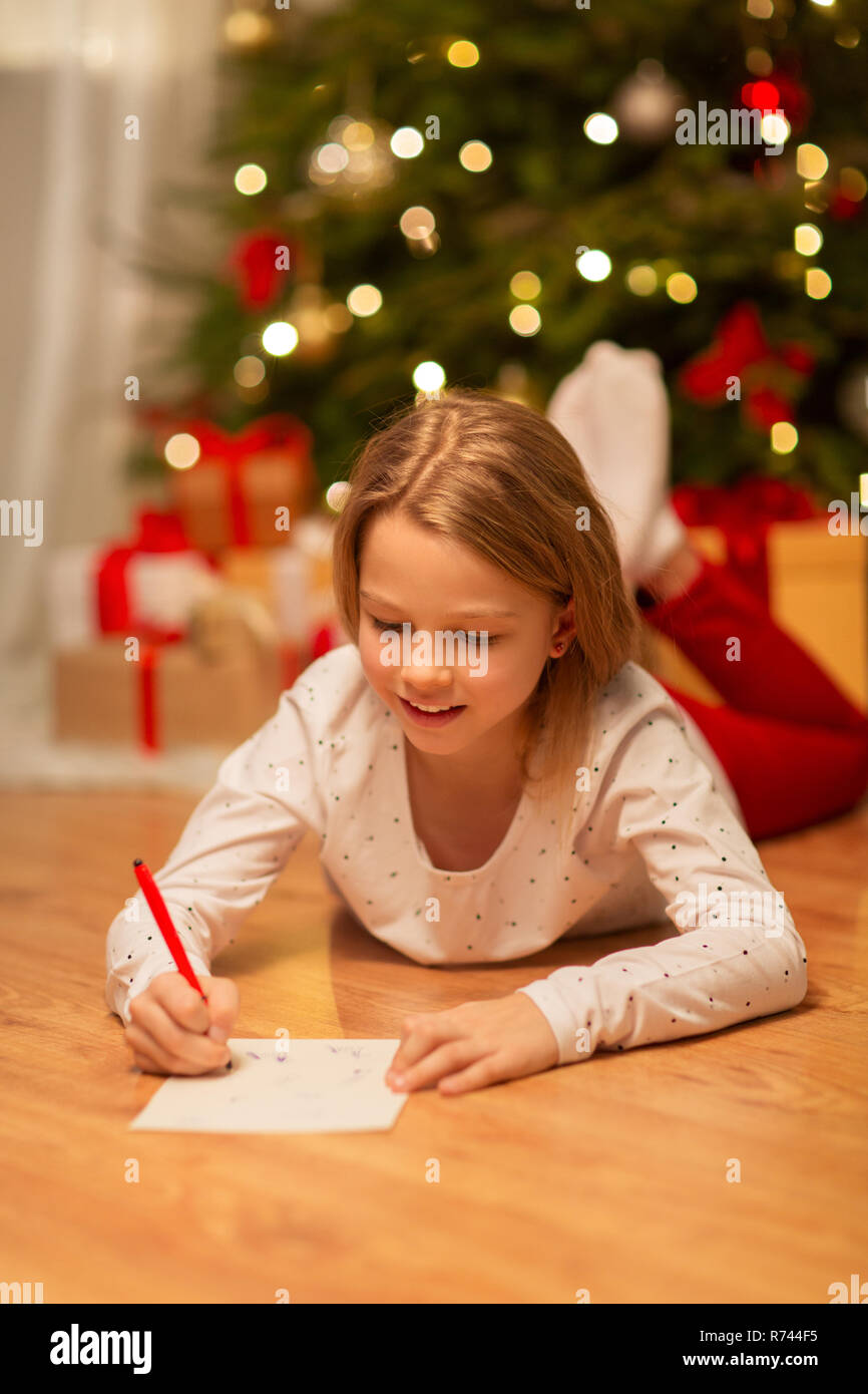 Smiling Girl Writing Christmas Wish List At Home Stock Photo Alamy