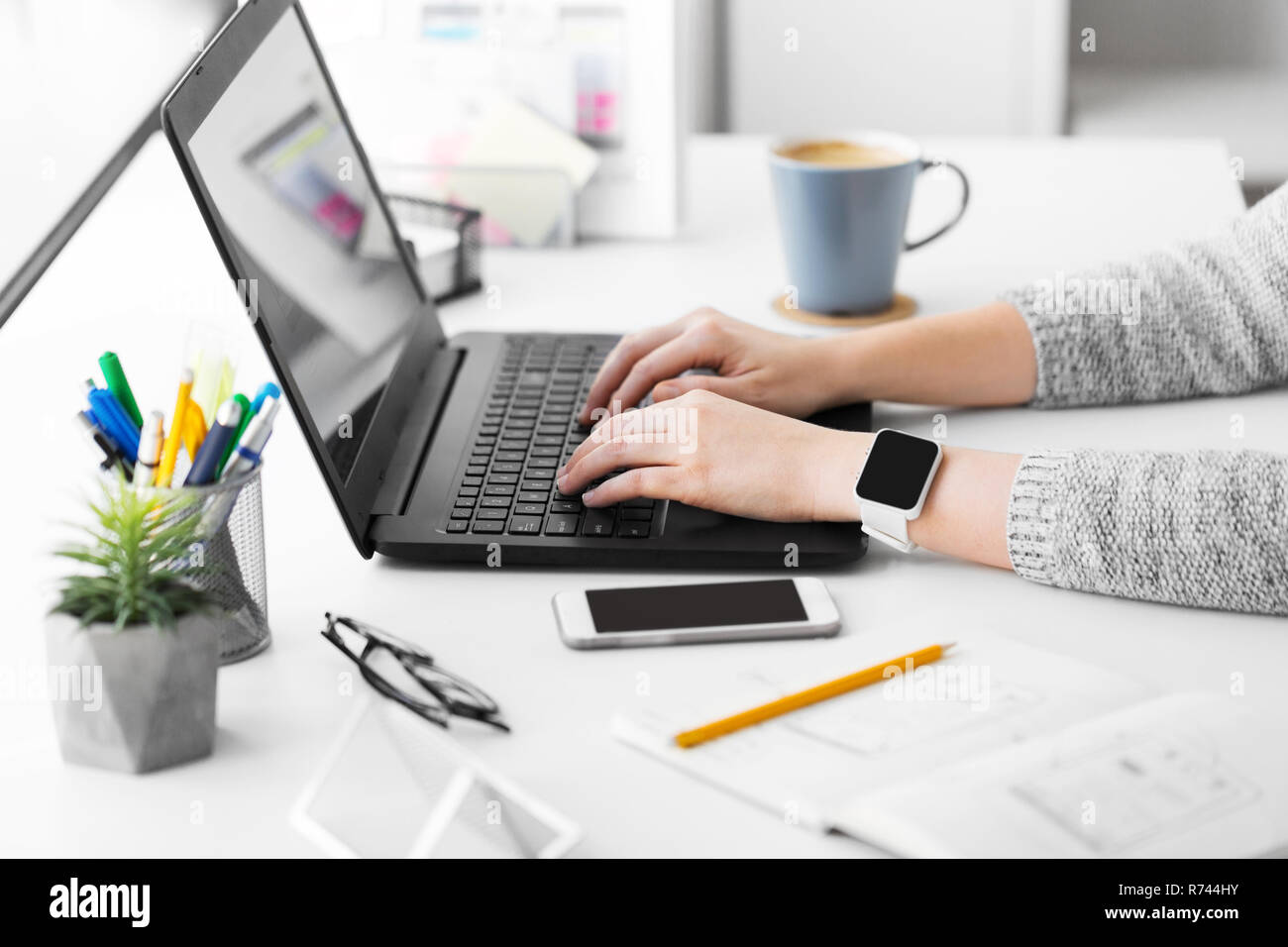 designer with smart watch and laptop at office Stock Photo - Alamy