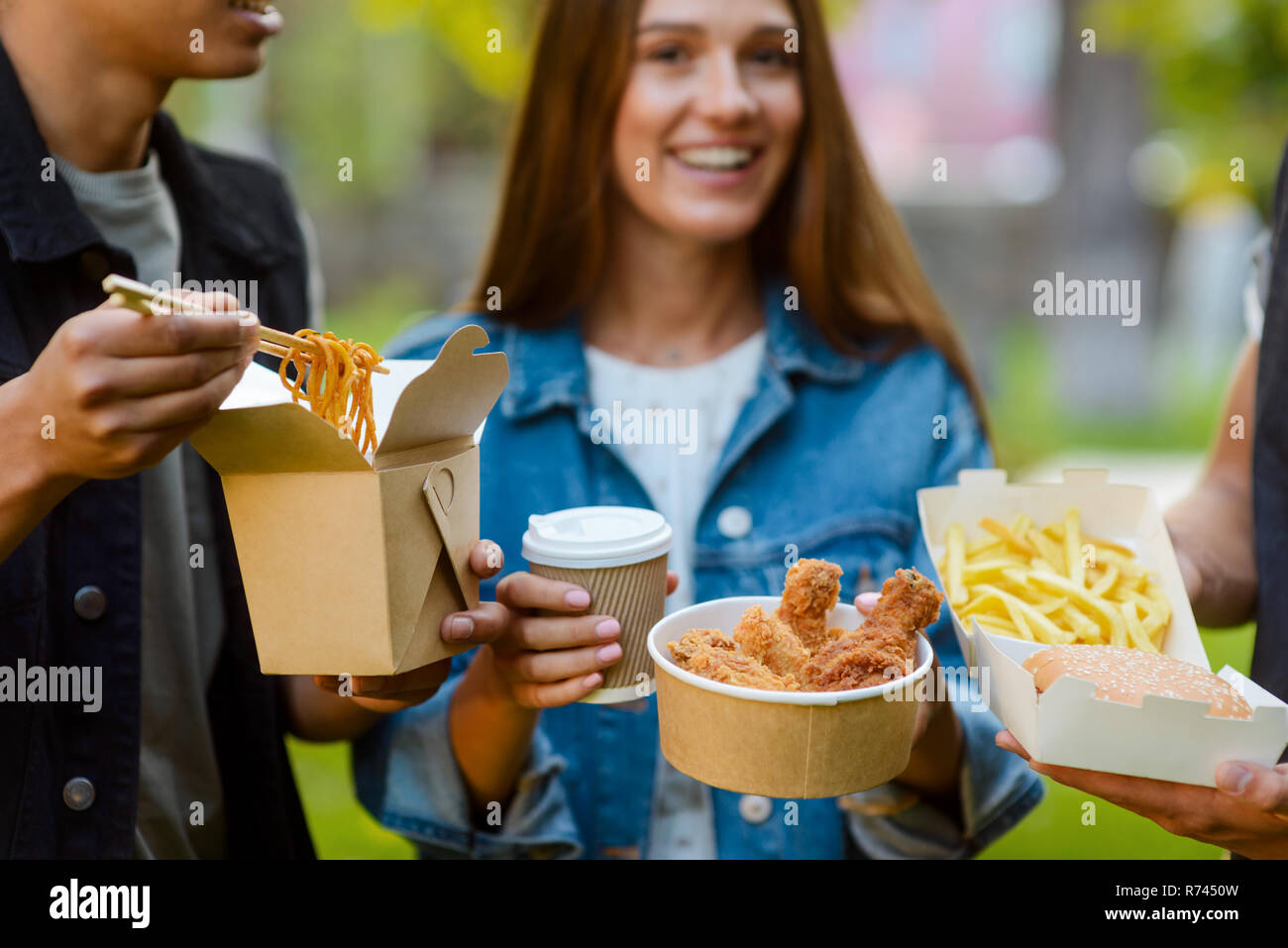Young people eating fast food Stock Photo - Alamy