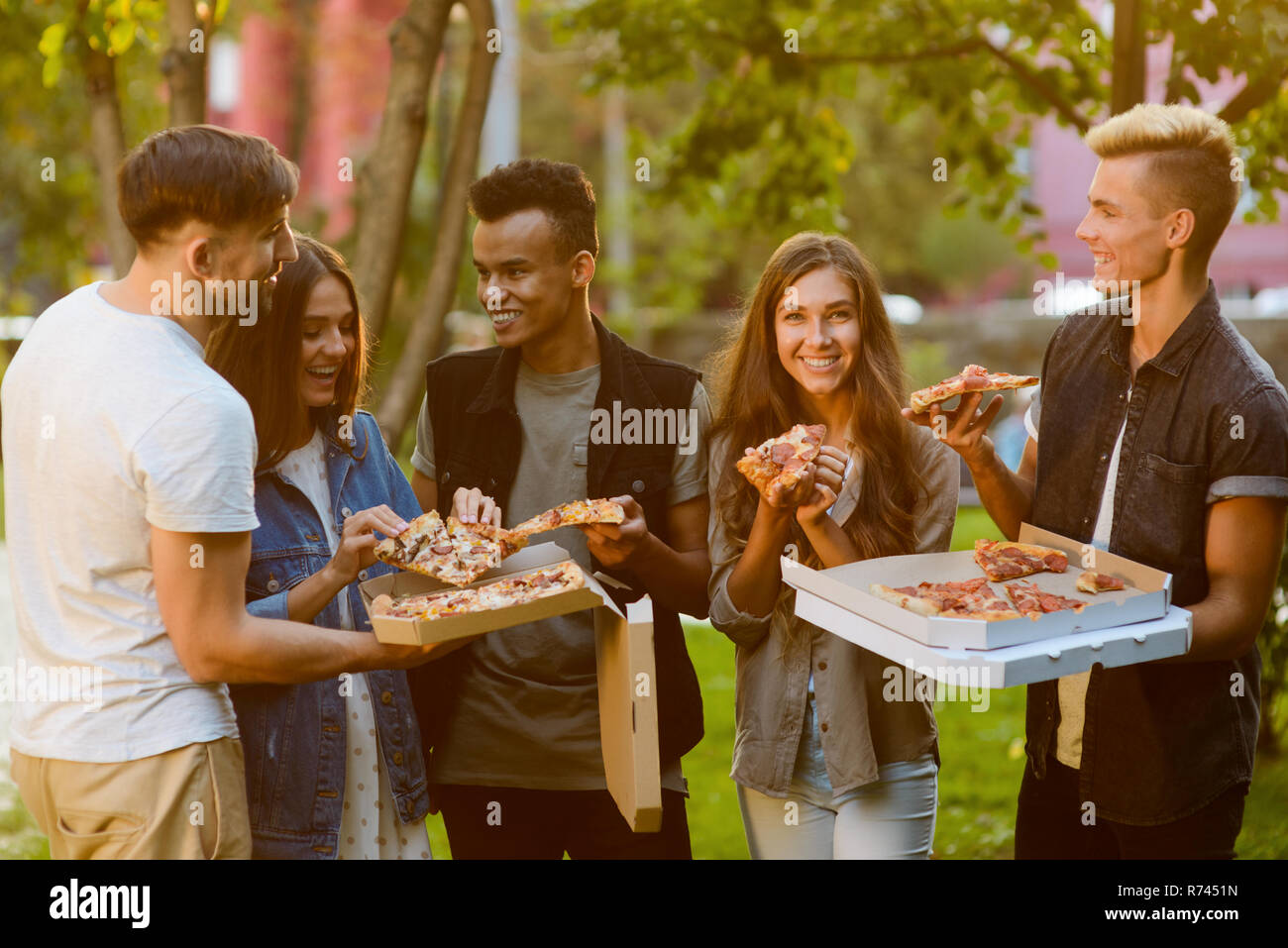 Happy students are eating pizza Stock Photo - Alamy