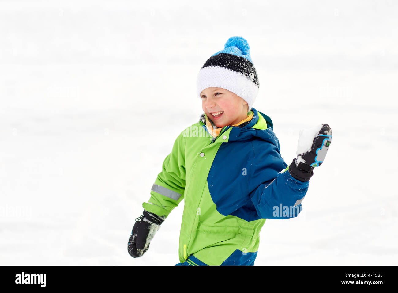 happy boy playing and throwing snowball in winter Stock Photo - Alamy