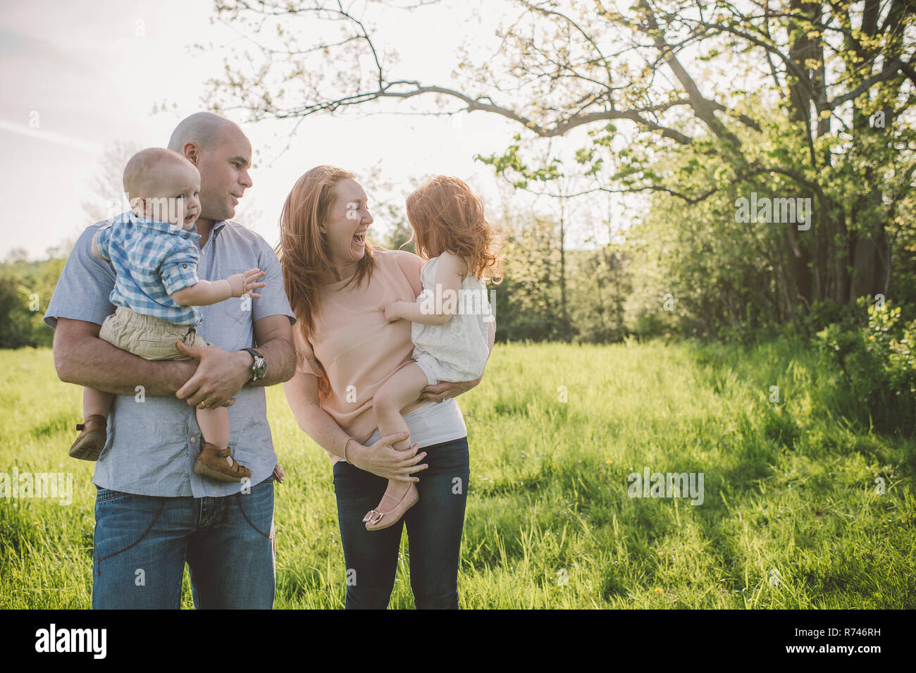 Parents and children taking walk in park Stock Photo - Alamy