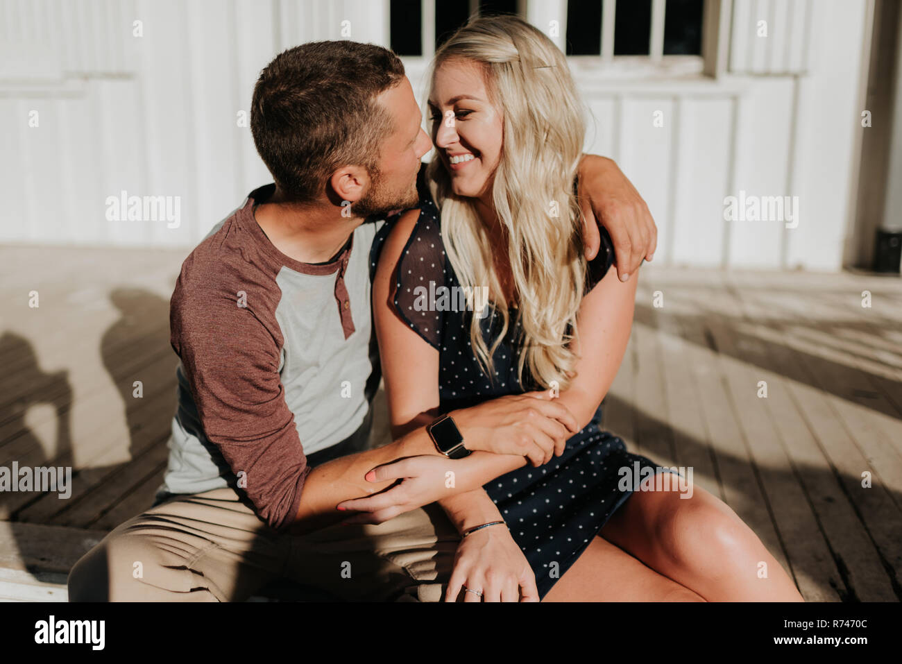 Romantic man and girlfriend sitting on porch gazing at each other Stock Photo - Alamy