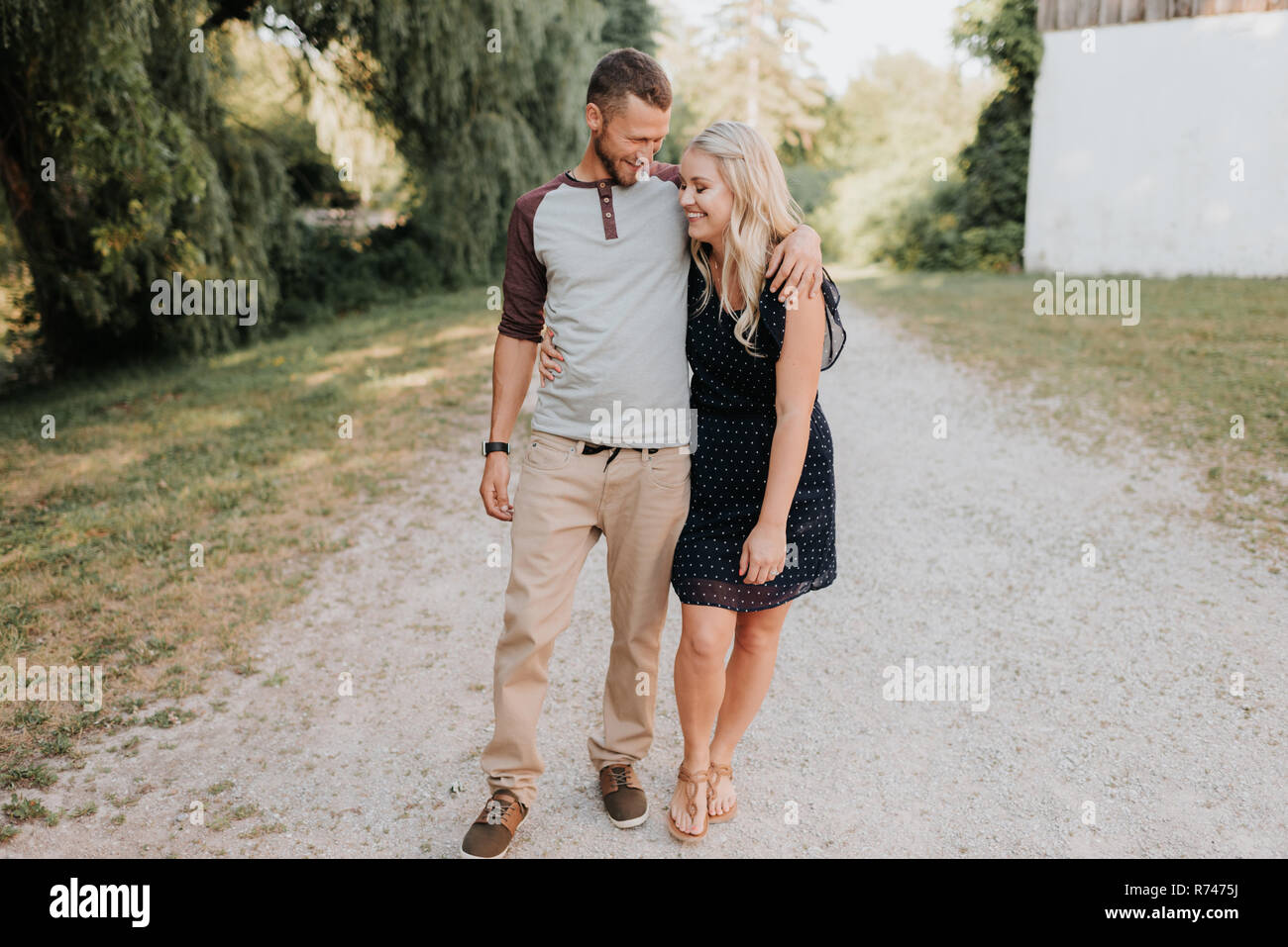 Romantic young woman and boyfriend strolling along dirt track Stock ...