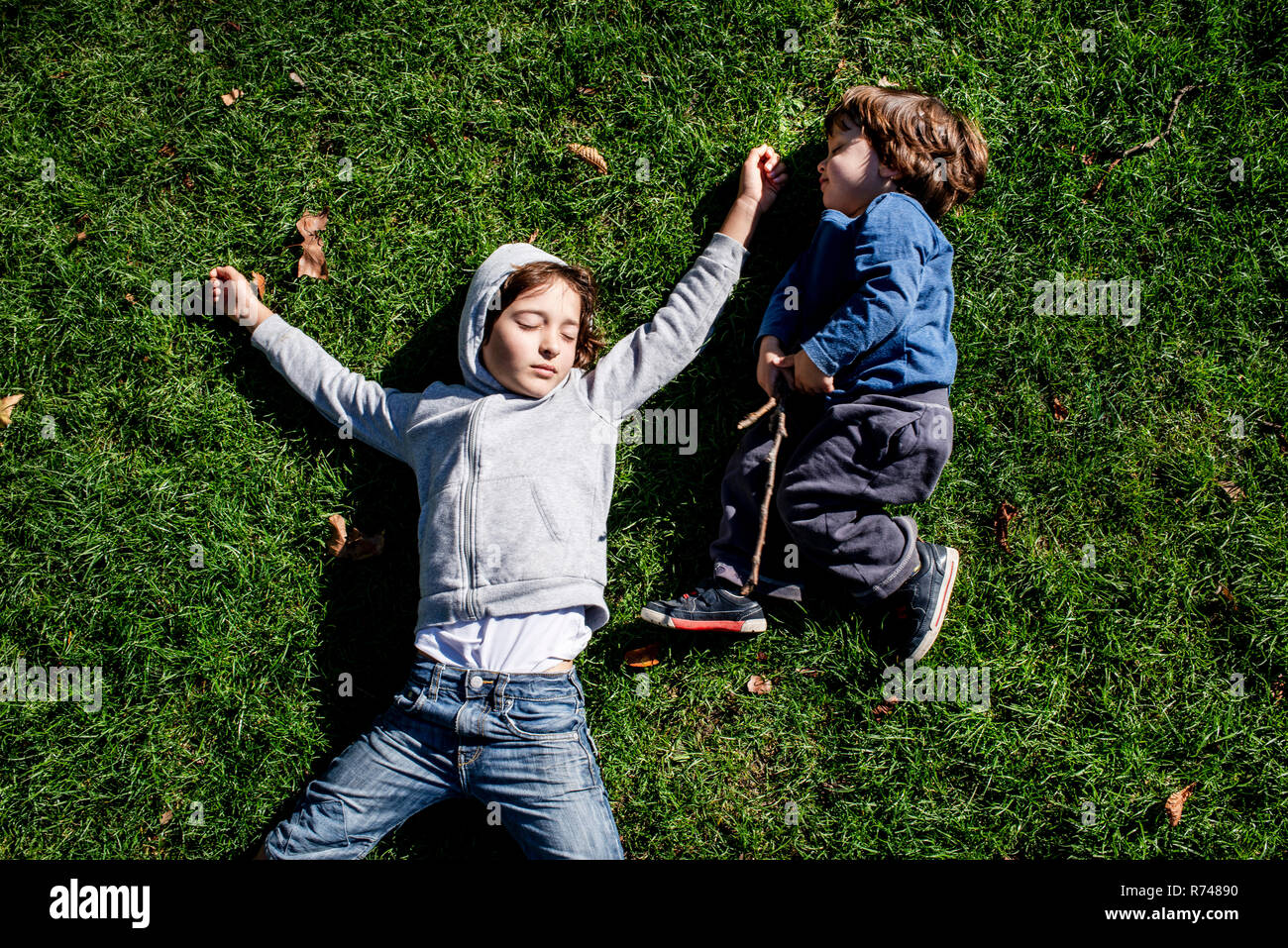 Boy lying on grass arms hi-res stock photography and images - Alamy