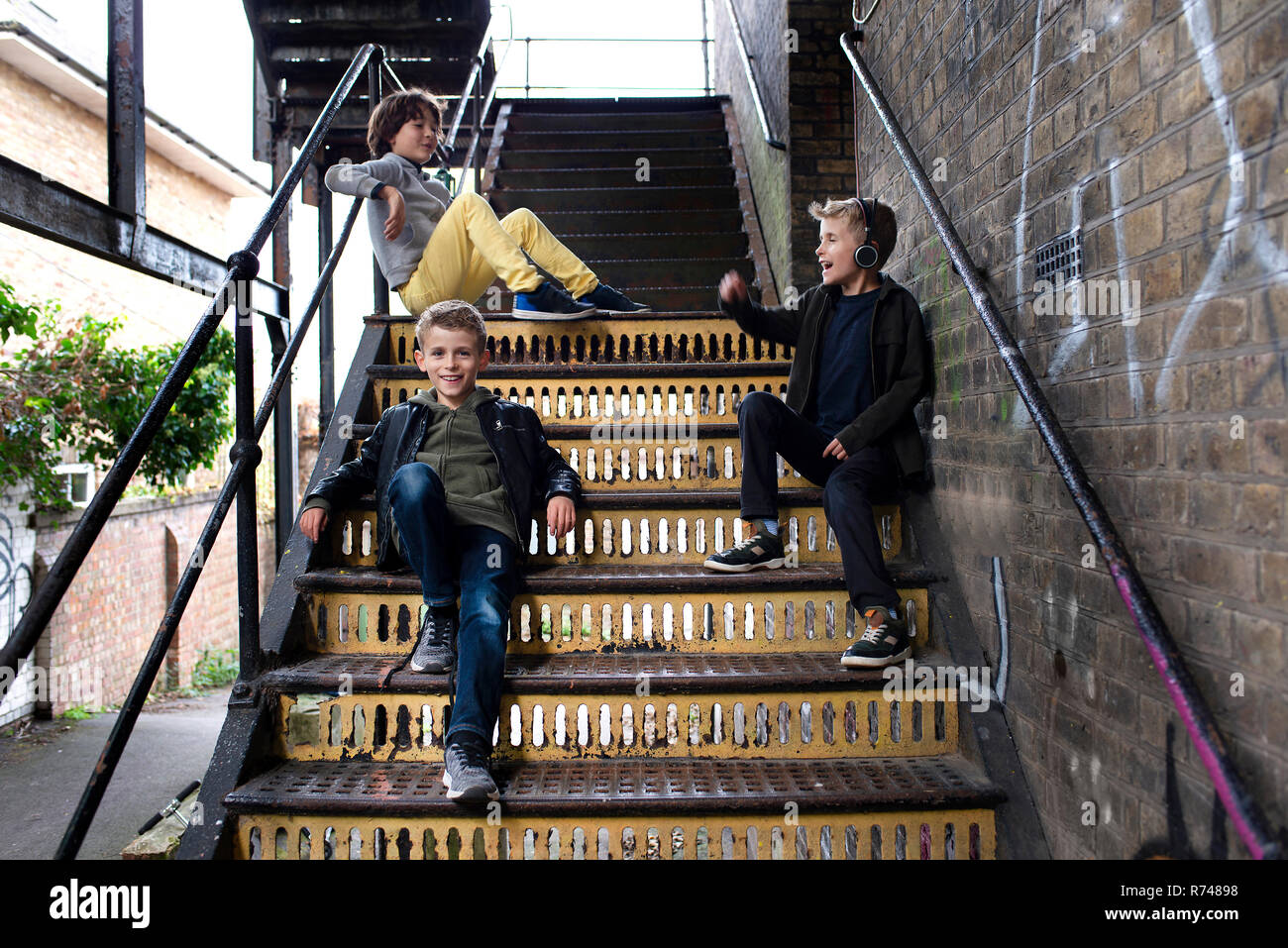 Boys talking on metal staircase Stock Photo - Alamy