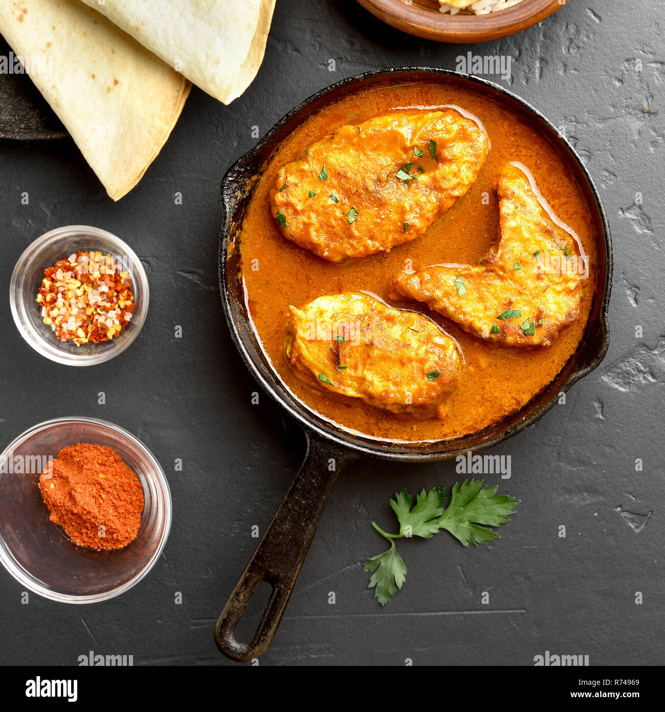 Tasty fish curry in pan on black stone table. Indian style food. Top ...