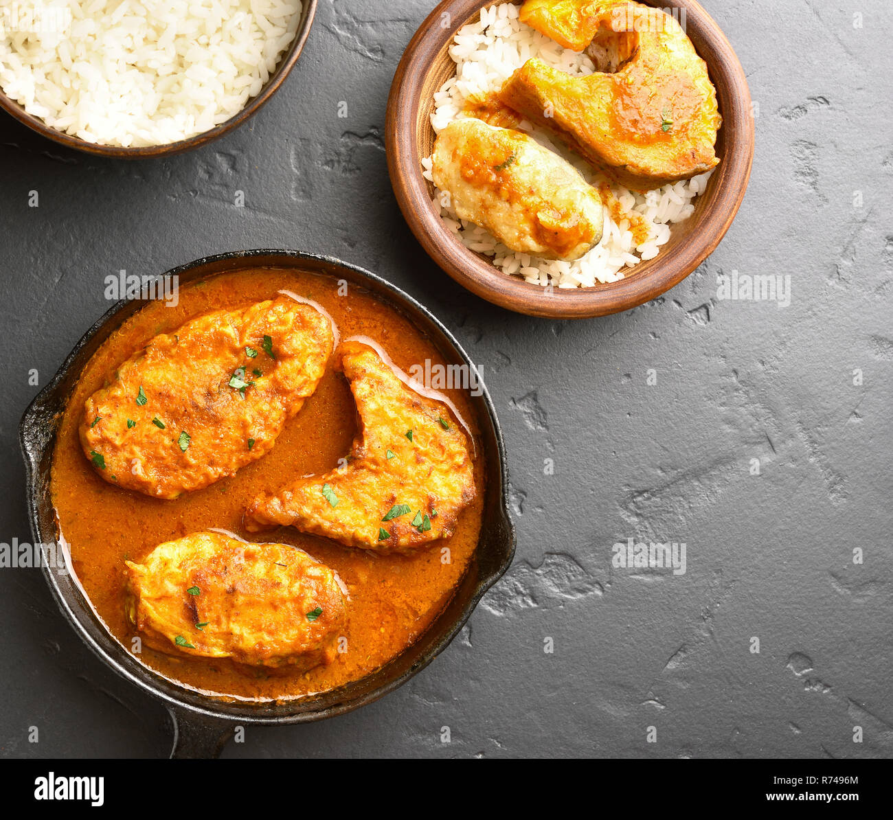 Indian style food. Fish curry on black stone background with copy space ...