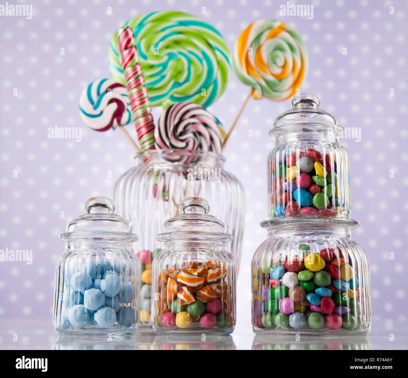 Colorful lollipops and different colored round candy and gum balls ...