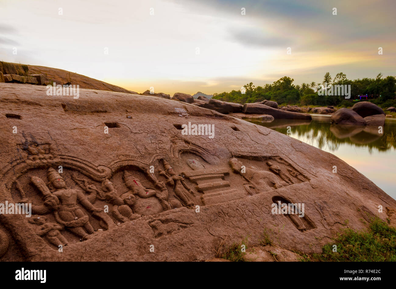 Carvings of Hindu deities on a rock beside Tungabhadra River viewed ...