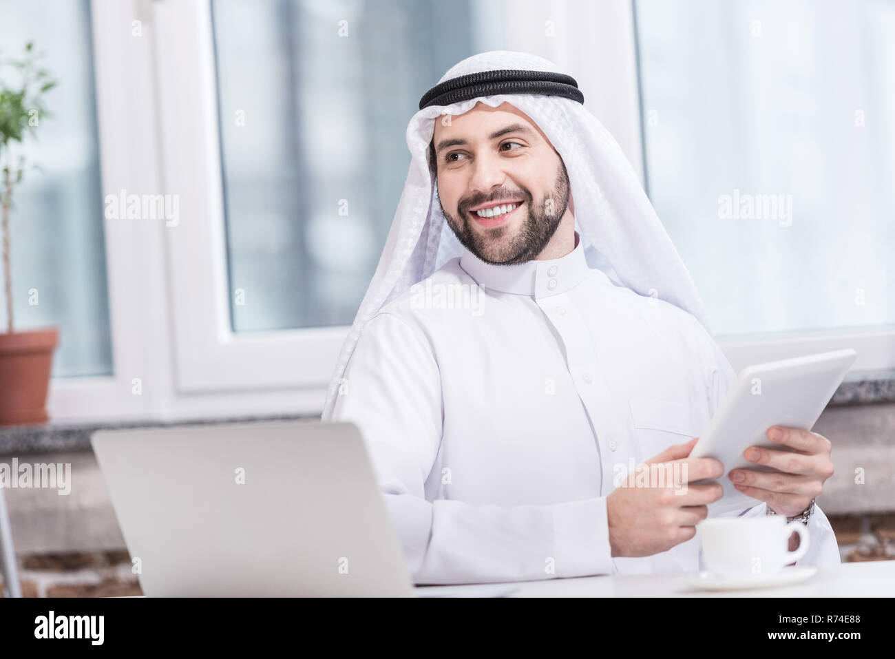 Arabian businessman holding digital tablet in modern office Stock Photo ...