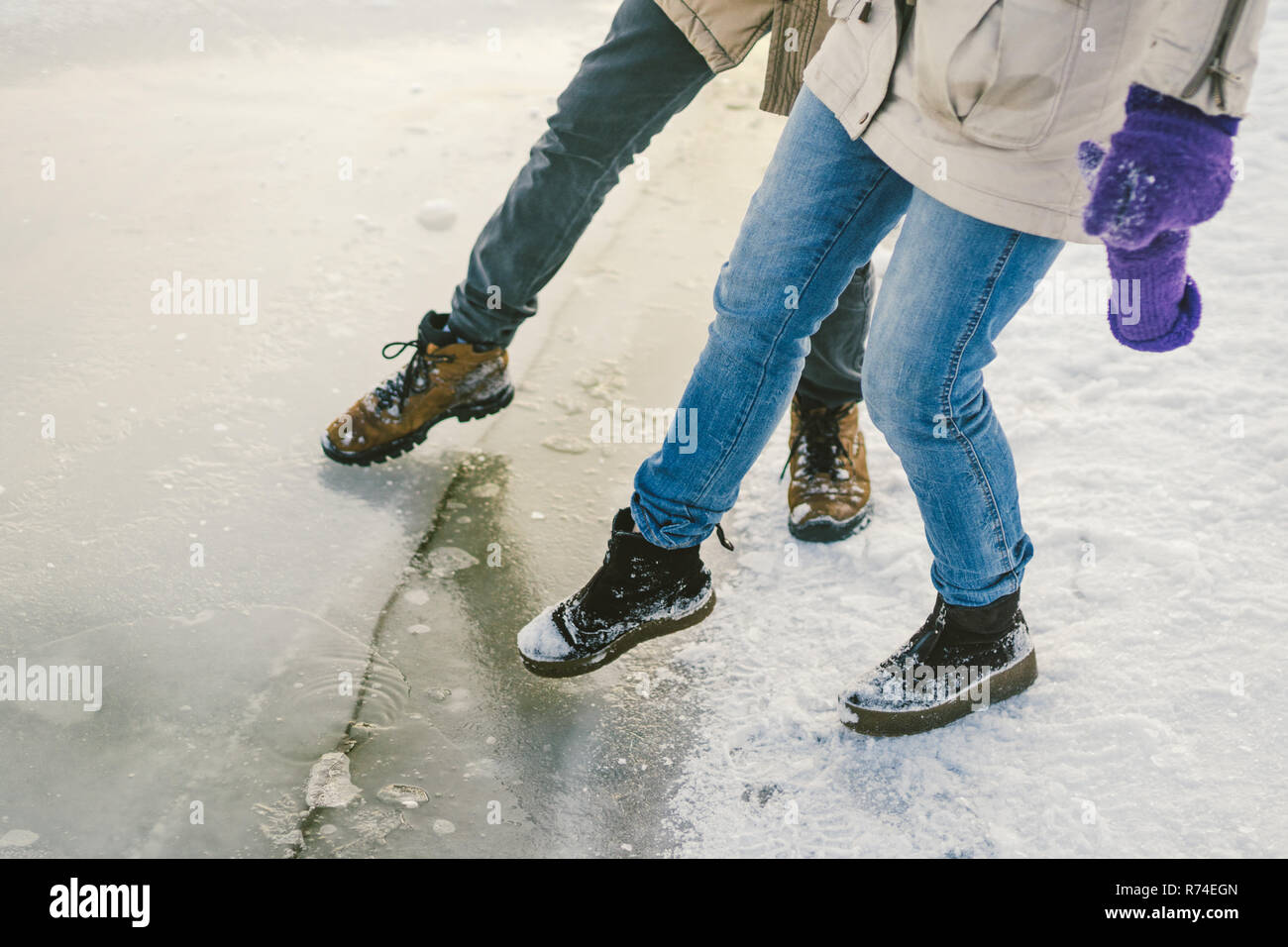 Trying the danger of the foot, testing the thin ice near the shore. A ...