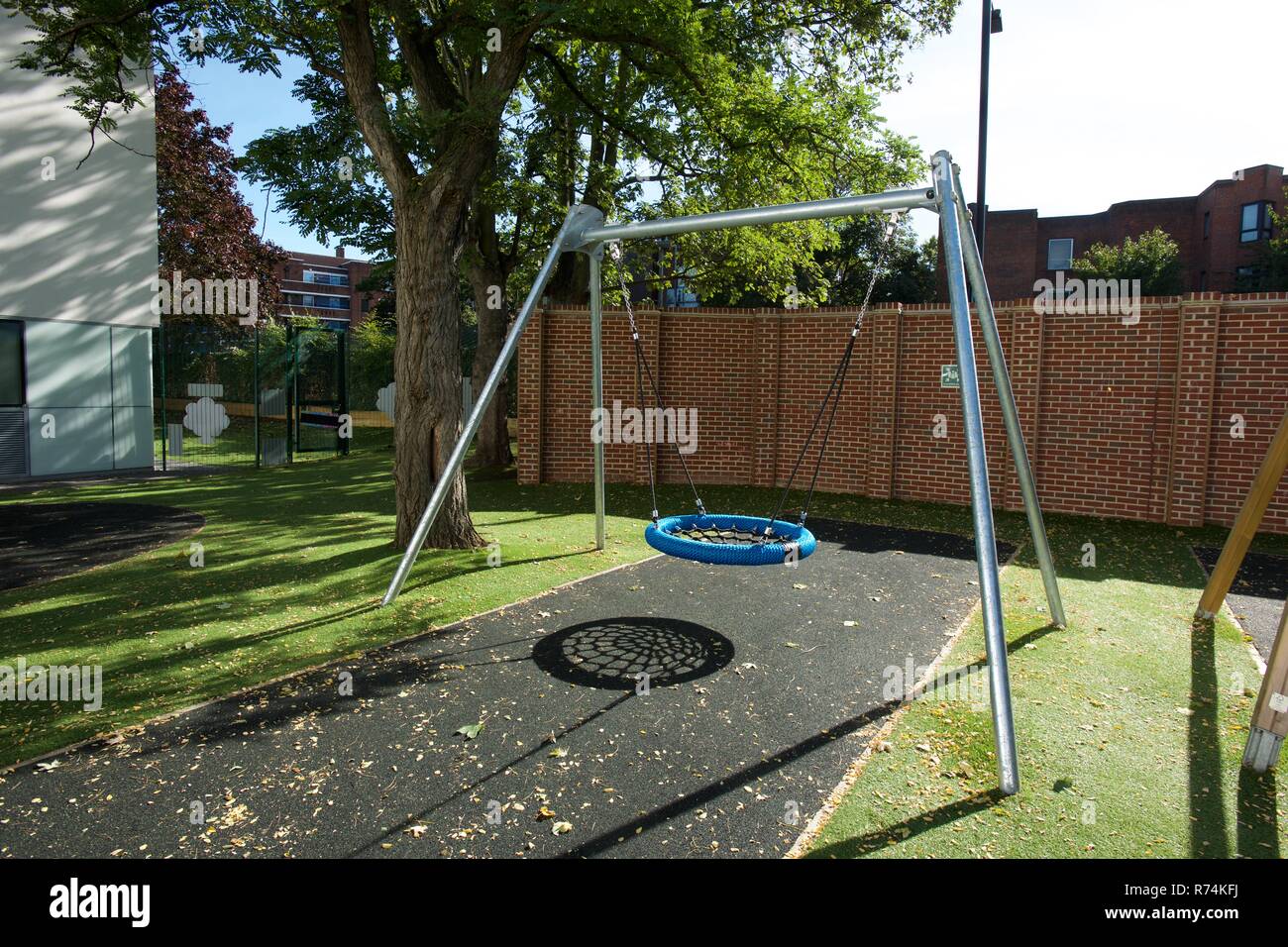 Modern safe playground with a large swing rubber mat and astroturf in ...