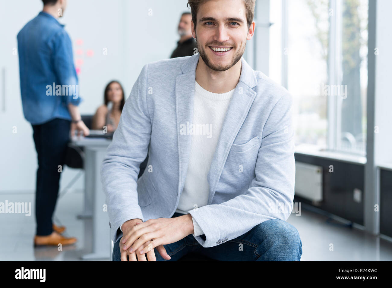 Enjoying his work. Handsome young man looking at camera and smiling ...