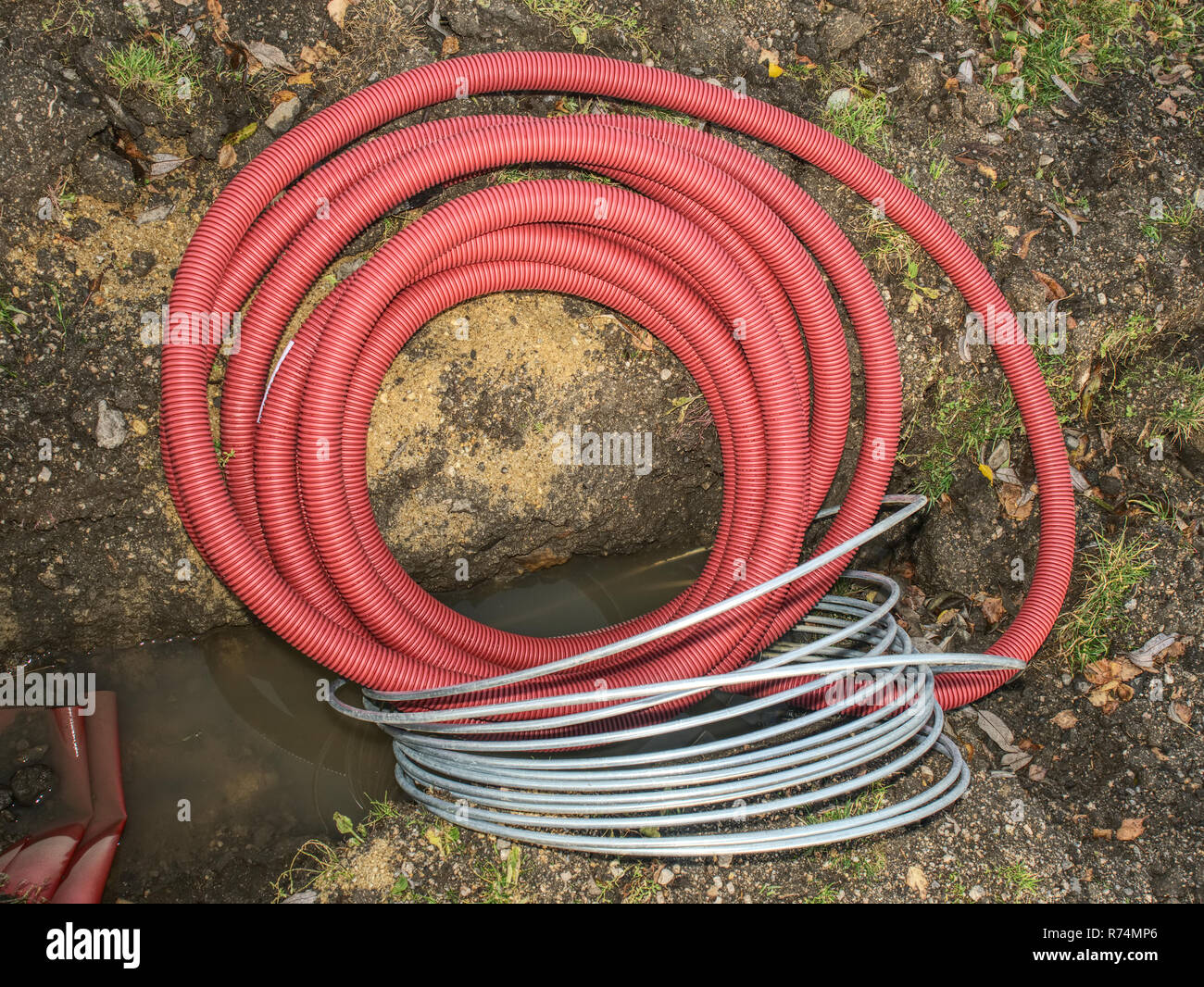 Electric cable in the flexible safety pipe in the pit Stock Photo - Alamy