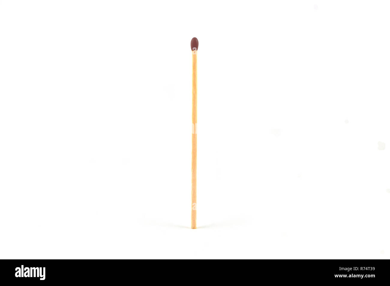 A big matchstick standing/balancing on white background Stock Photo - Alamy