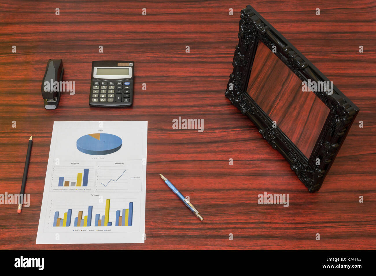 Sheet of paper with printed graphs on a desk with pen, pencil and ...
