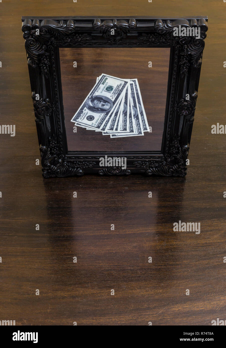 Money reflection in front of a mirror. Both objects are lying on a ...