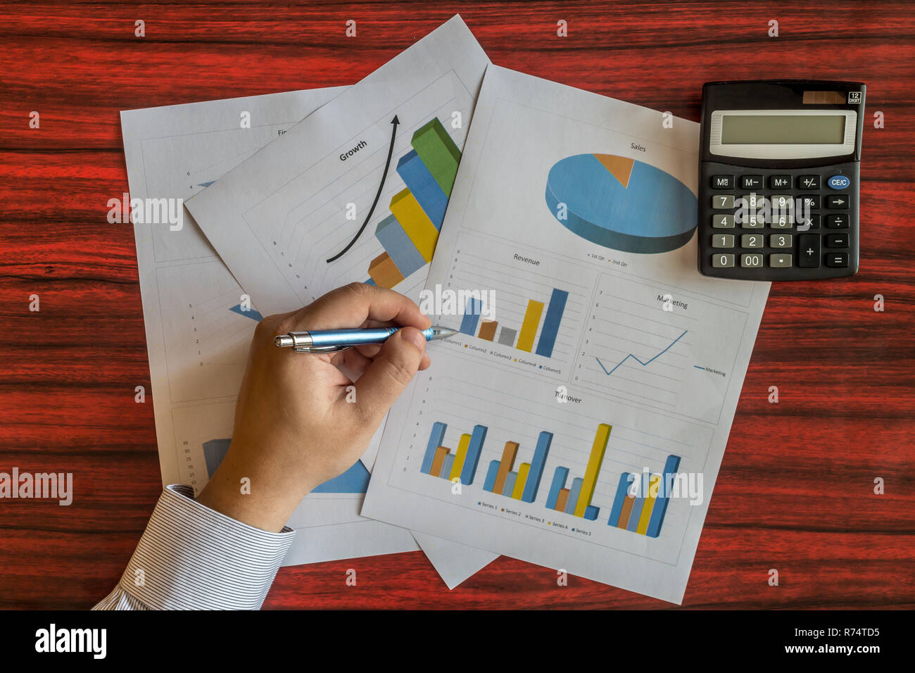 Left handed person analyzing charts Stock Photo - Alamy